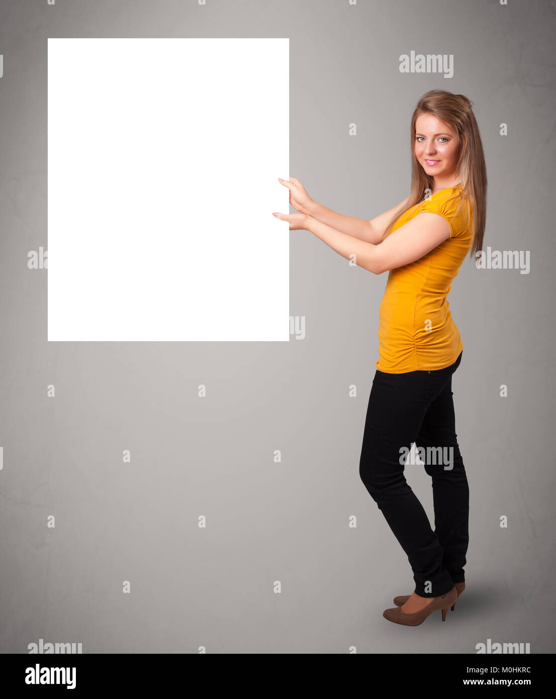 Pretty young woman presenting white paper copy space Stock Photo - Alamy