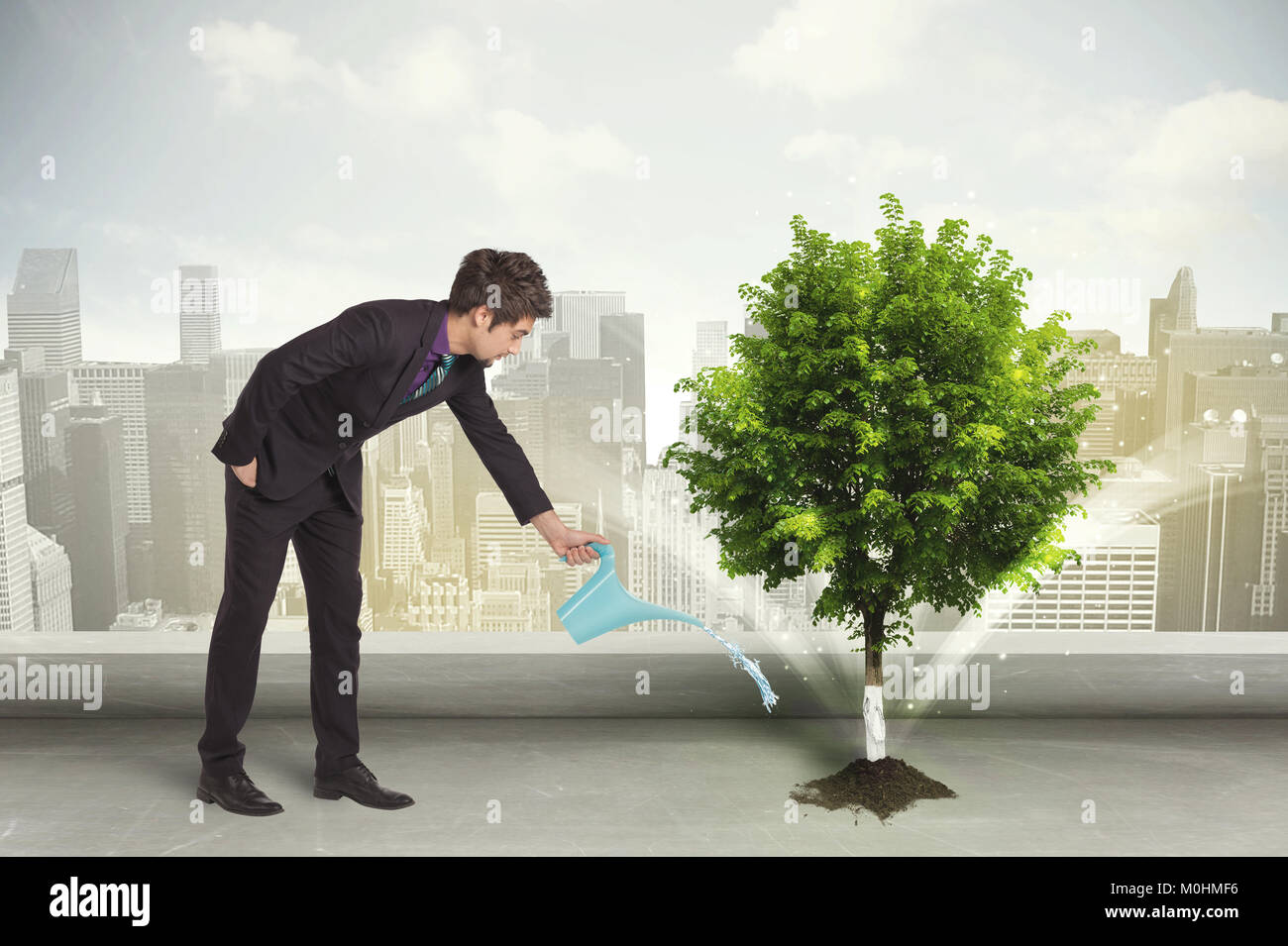 Businessman watering green tree on city background concept Stock Photo ...