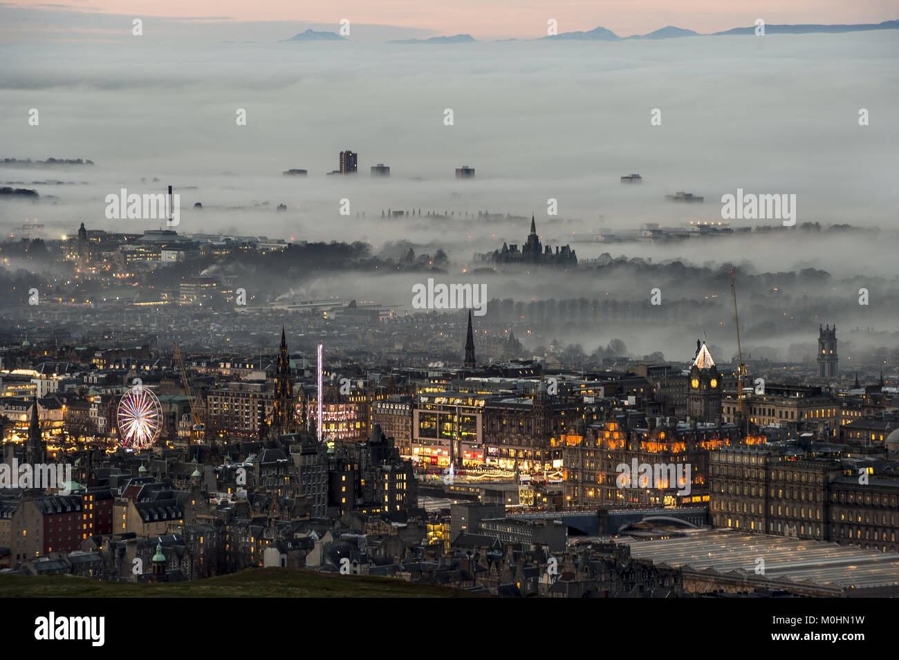 A thick mist rolls over Edinburgh city centre as shoppers crowd the ...