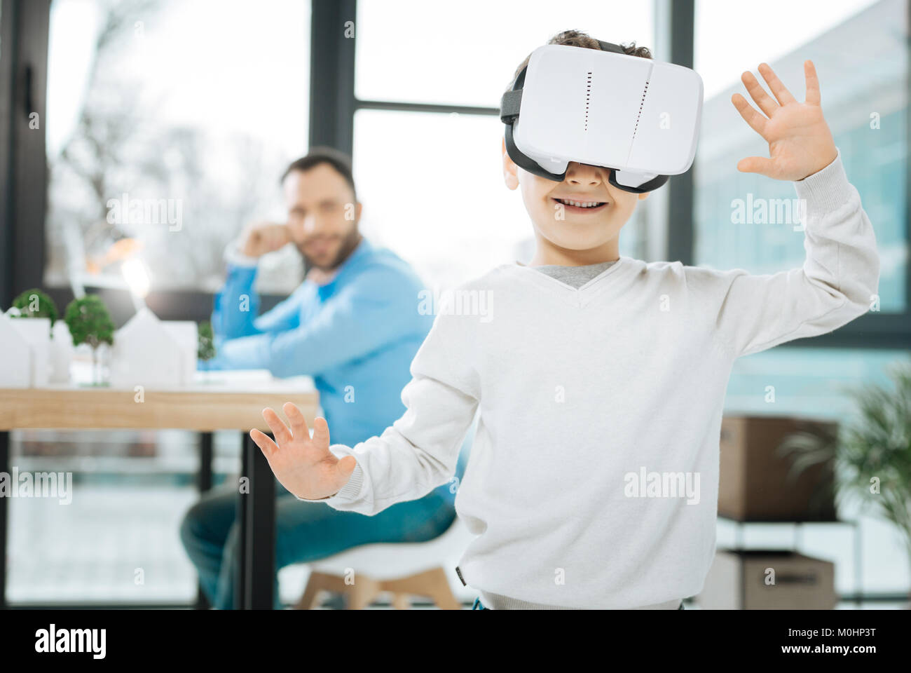 Cute boy trying out VR headset at fathers work Stock Photo - Alamy