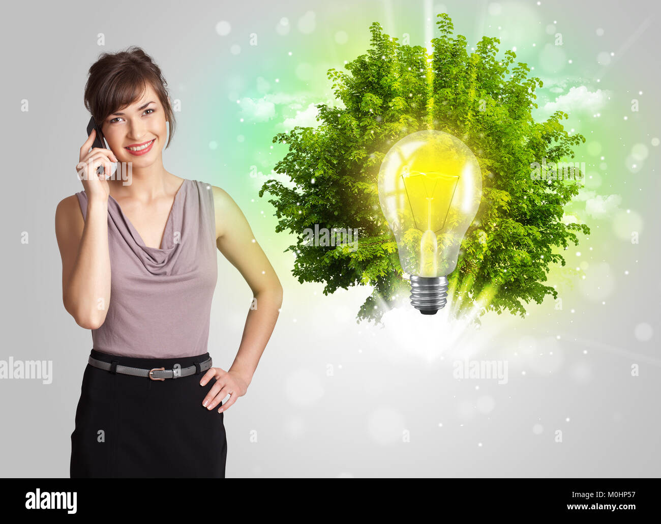 Young girl presenting idea light bulb with green tree concept Stock ...