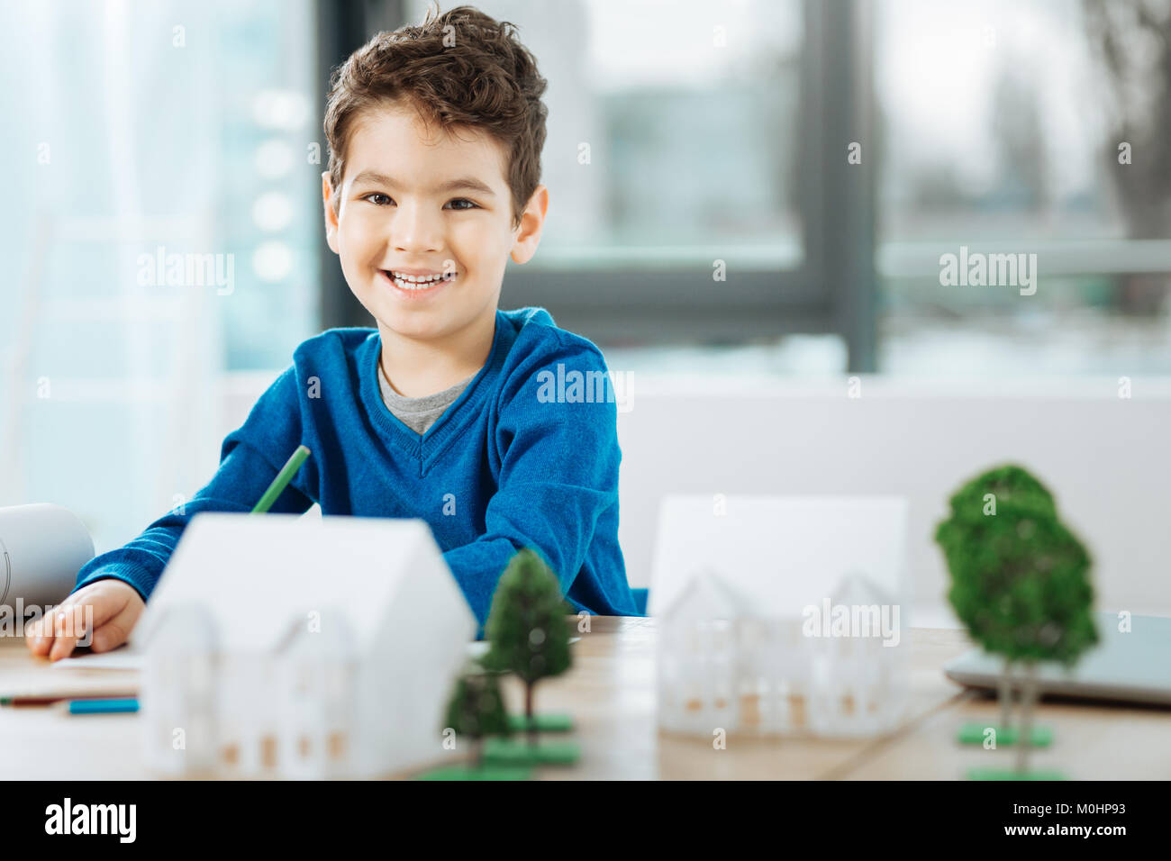 Upbeat boy drawing a picture and smiling Stock Photo - Alamy