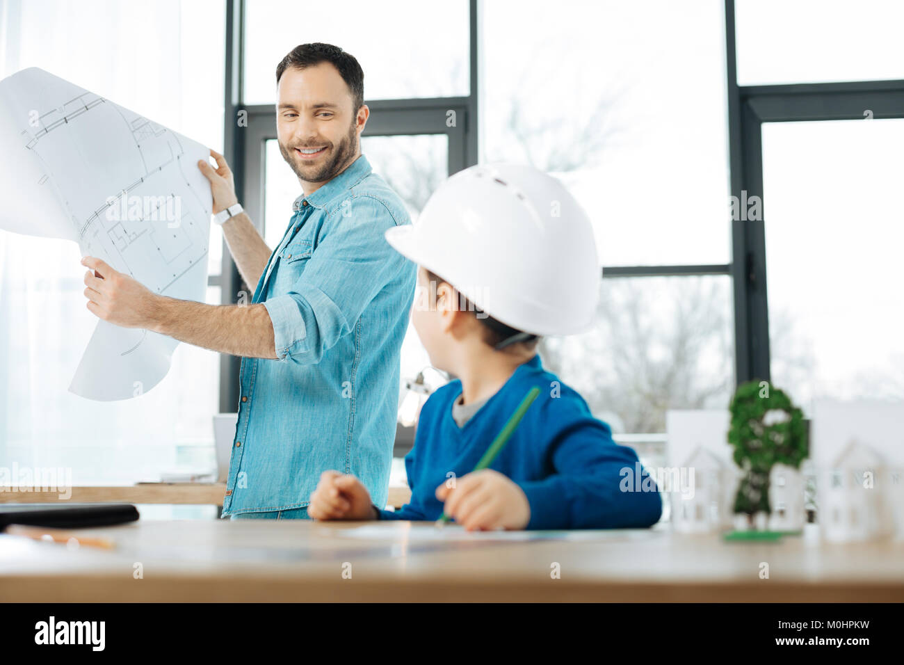 Little boy looking at his father holding blueprint Stock Photo - Alamy