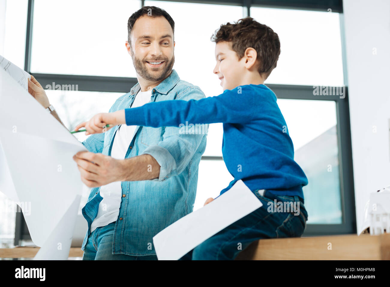 Adorable boy pointing at blueprint in his fathers hands Stock Photo - Alamy