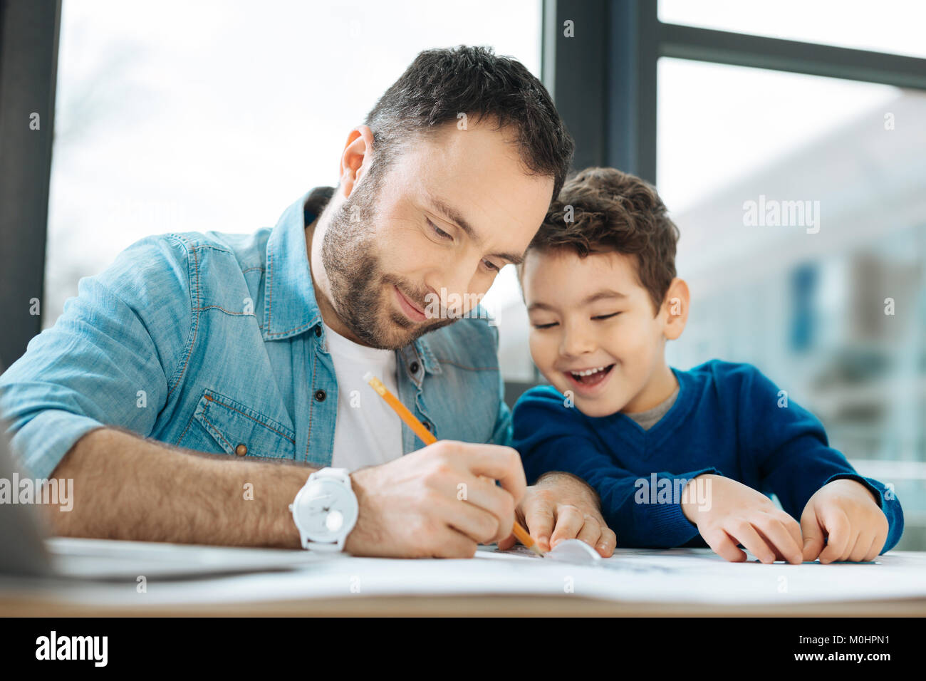 Little boy watching his father drawing lines on blueprint Stock Photo ...