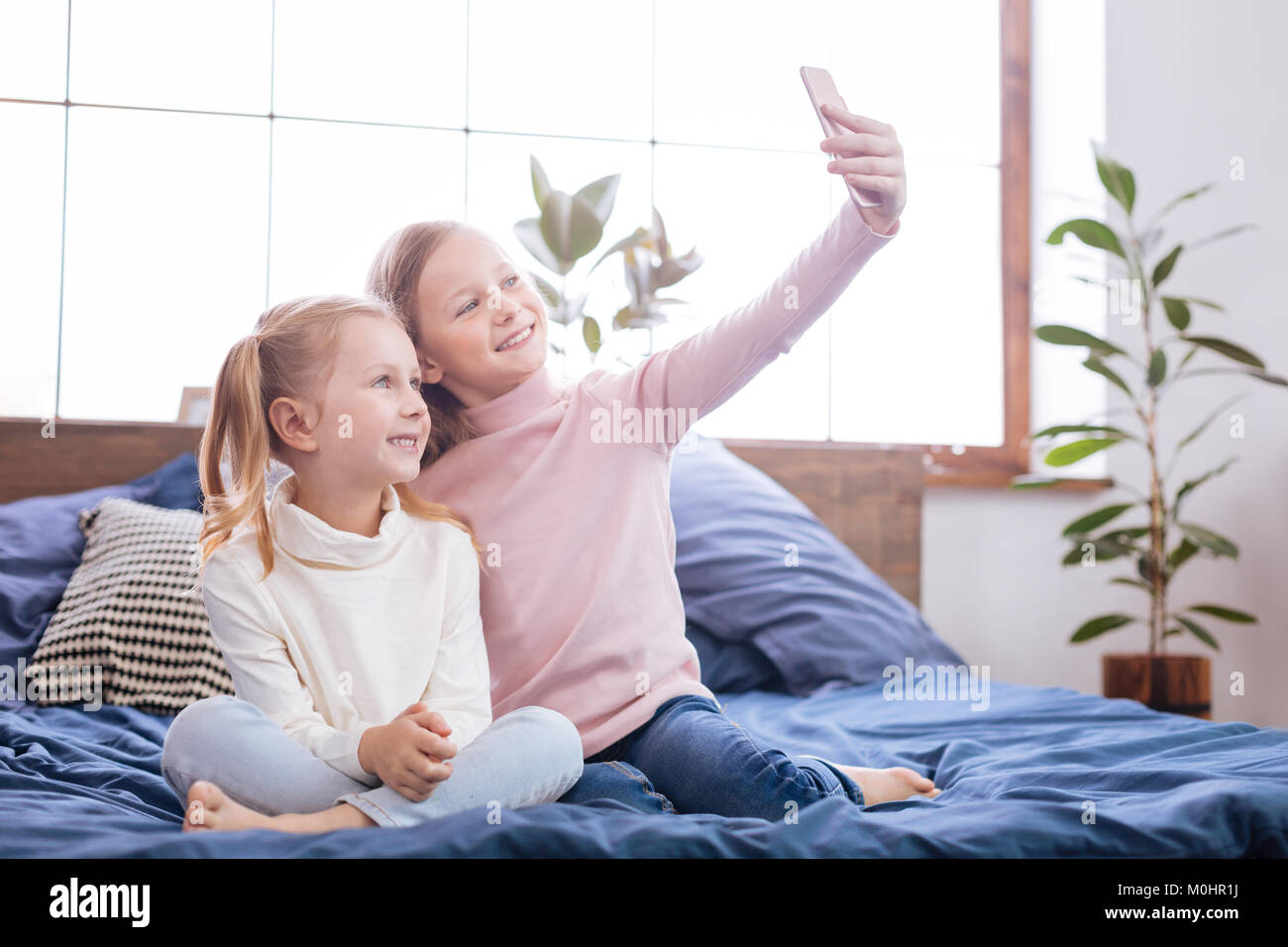 Inspired sisters taking pictures on their phone Stock Photo - Alamy