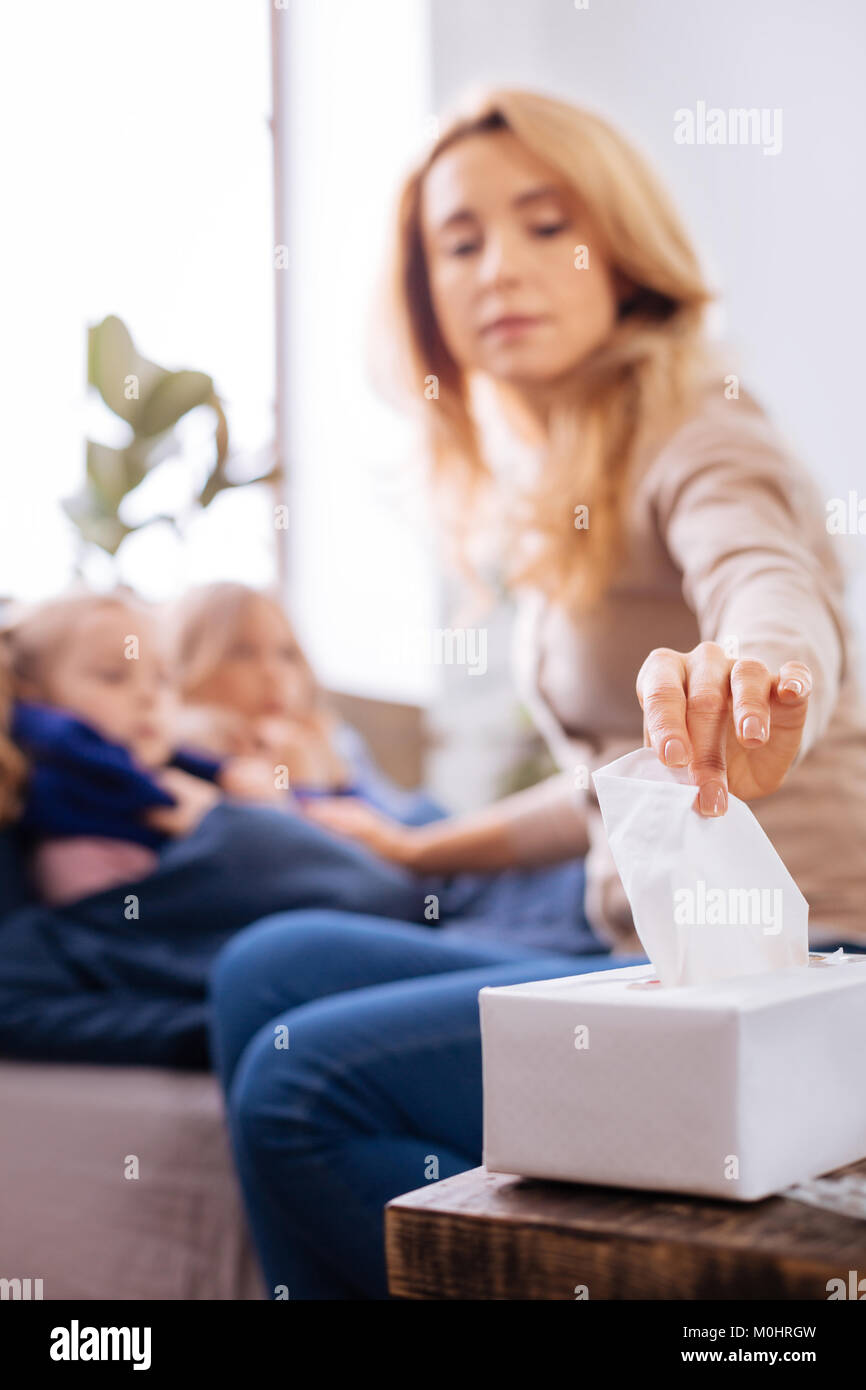 Troubled mother sitting near her sick children Stock Photo - Alamy