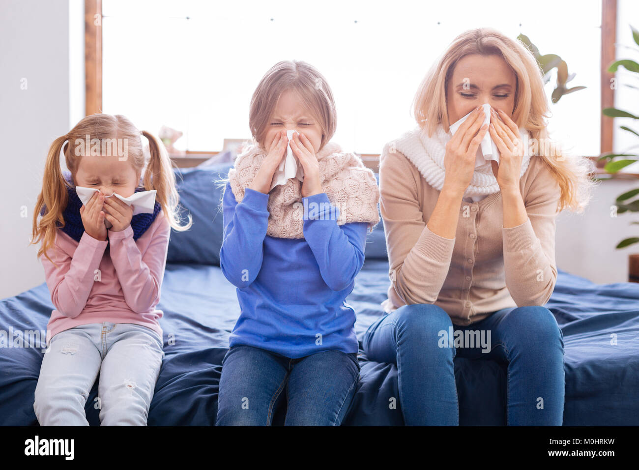 Sick mother and her daughters having a cold Stock Photo - Alamy