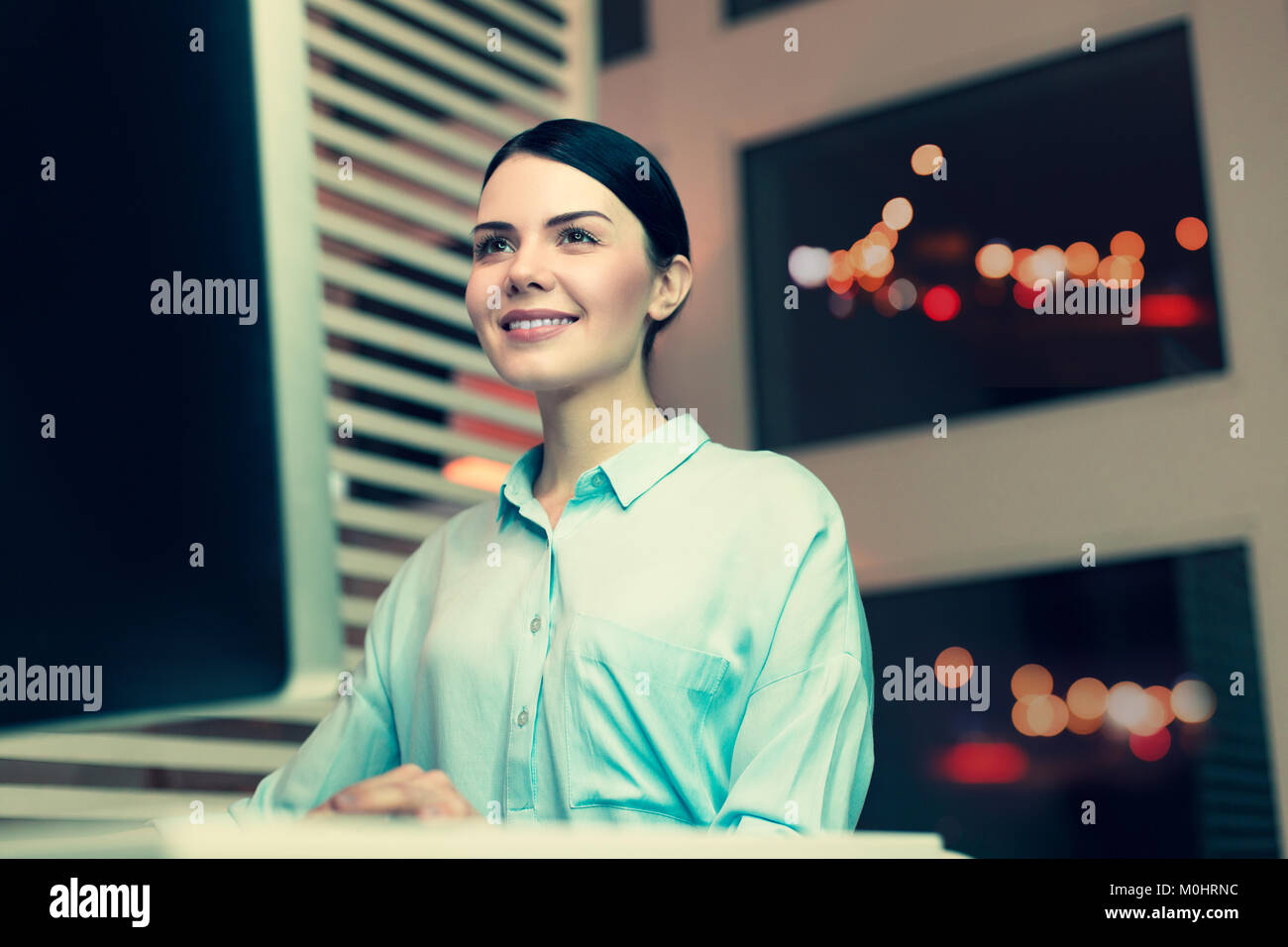Cheerful young woman reading from computer at work Stock Photo - Alamy