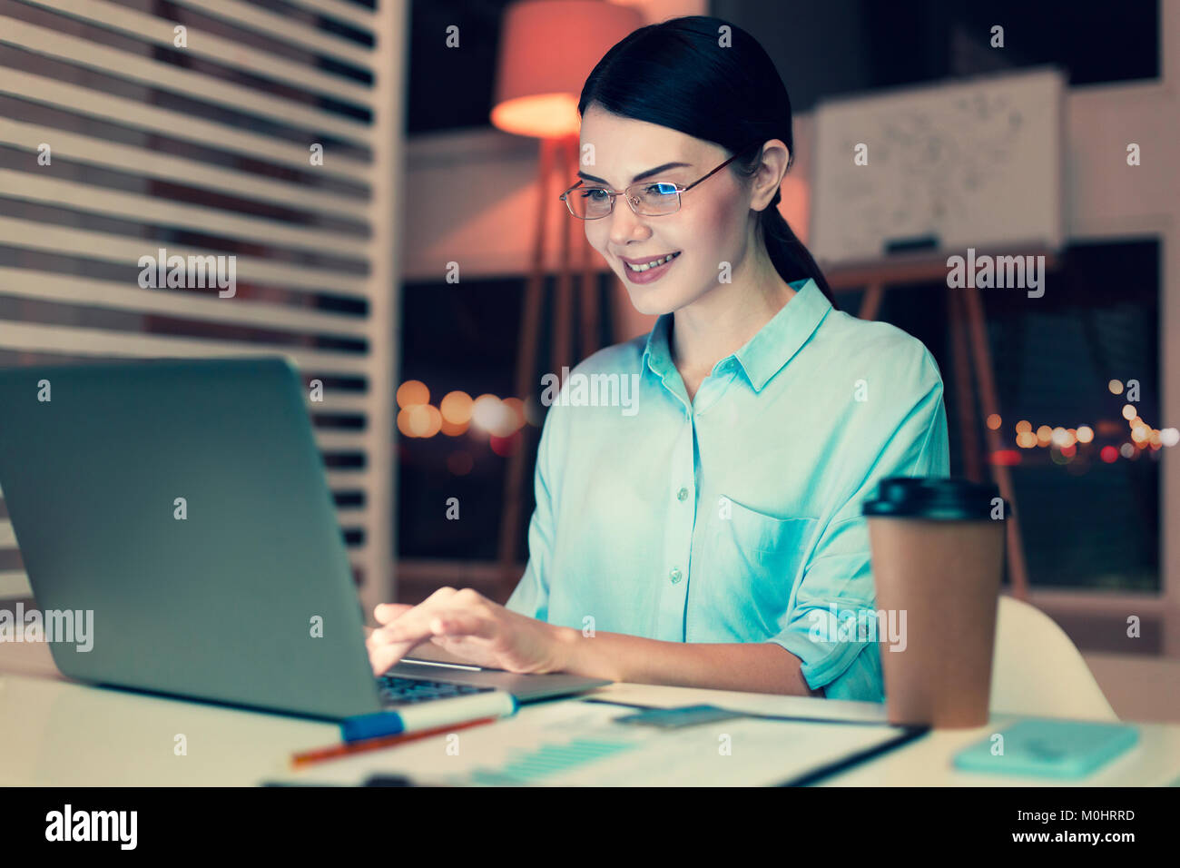 Charming young woman staying late at work Stock Photo - Alamy