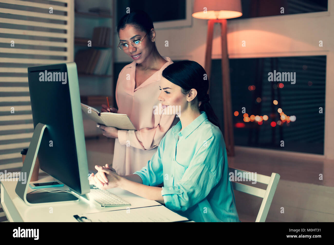 Pleasant boss taking notes while monitoring employees research Stock ...