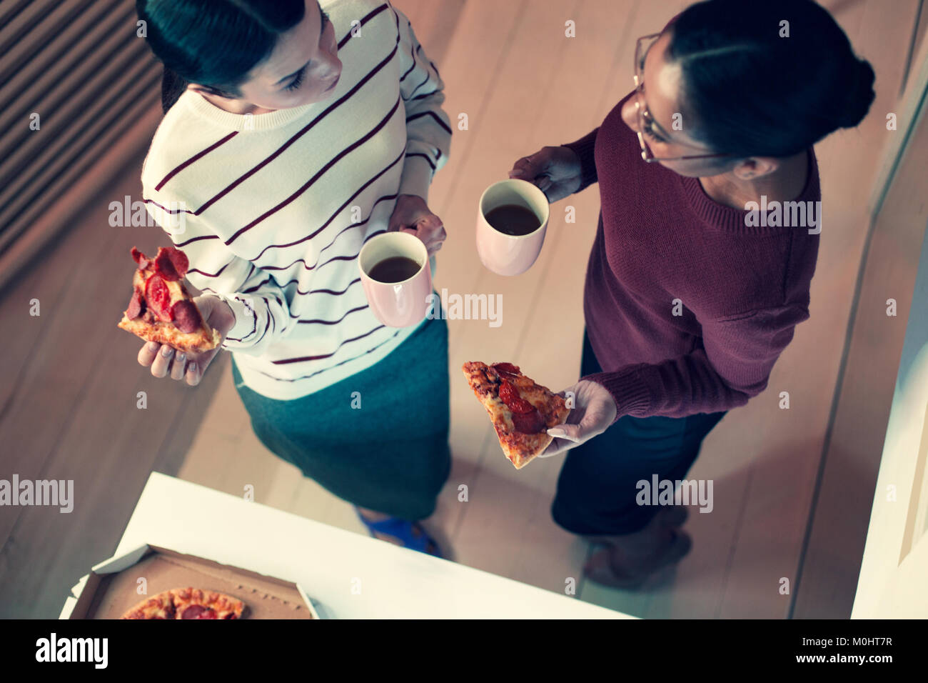 Top view of two women enjoying pizza and tea Stock Photo - Alamy