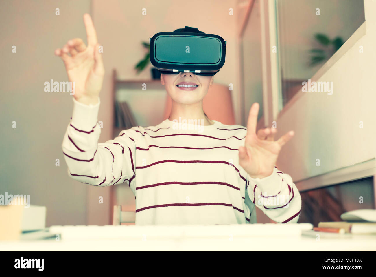 Charming young woman using VR headset at work Stock Photo - Alamy