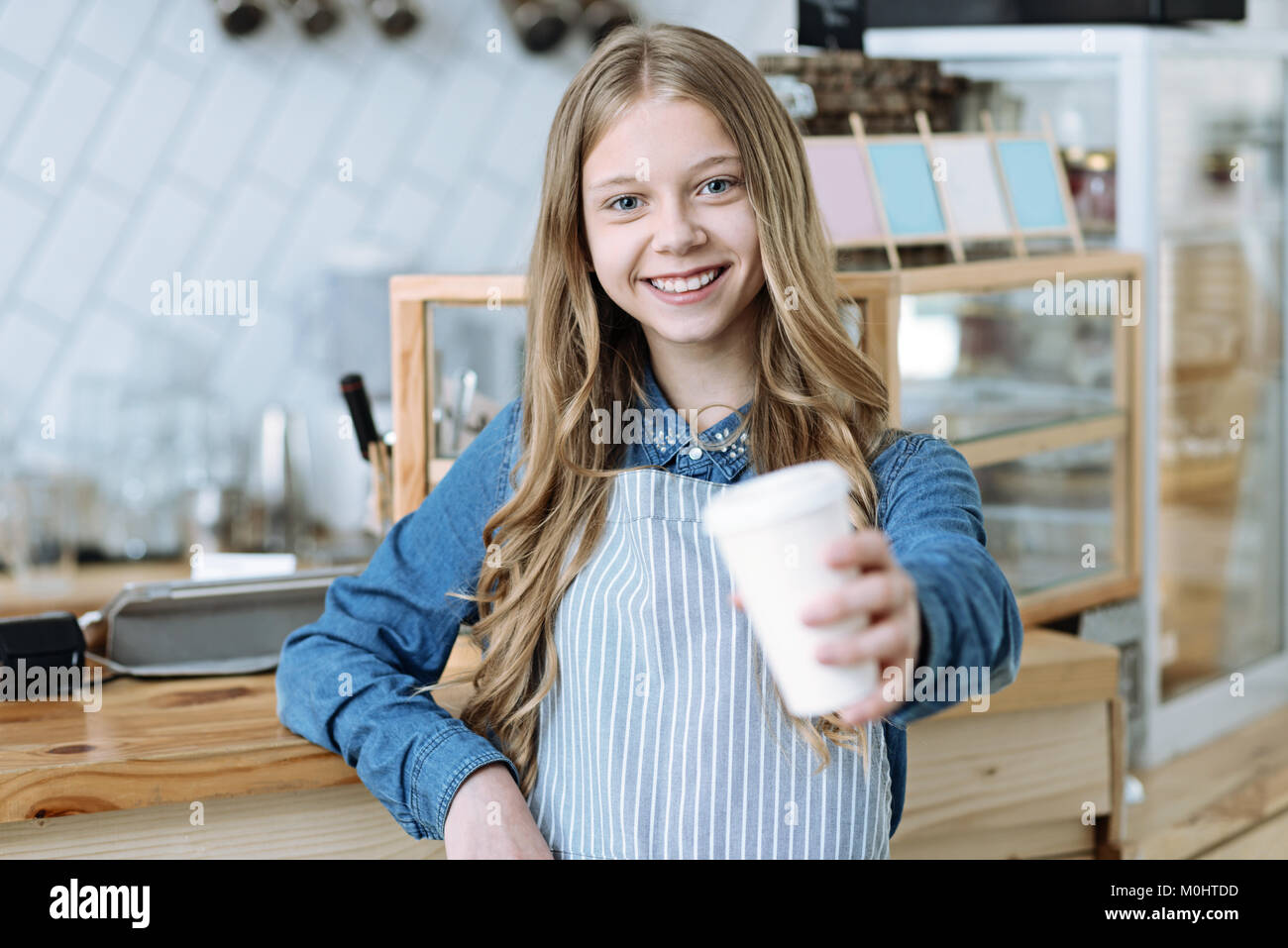 Cheerful girl stretching her hand with cup Stock Photo - Alamy