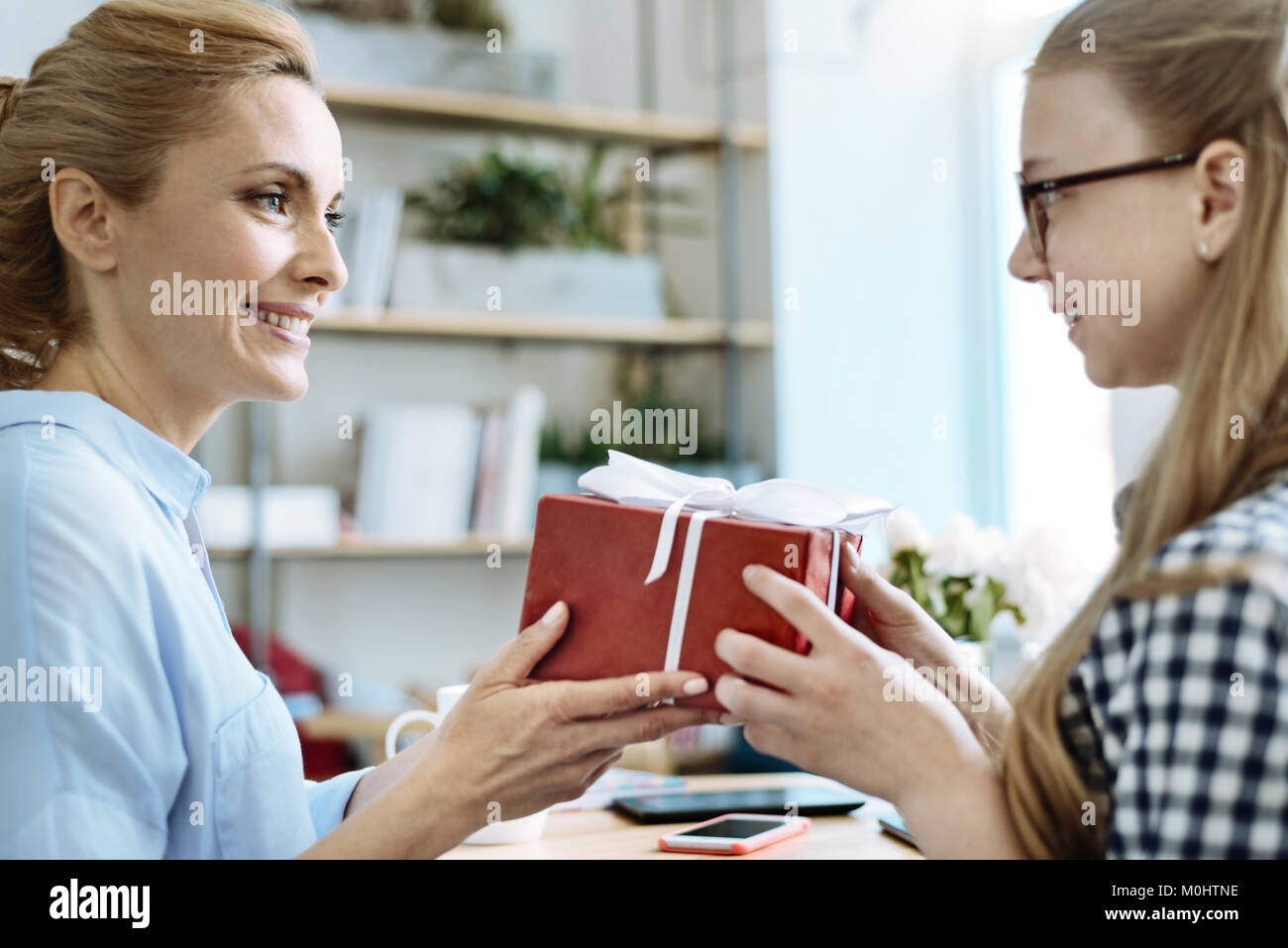 Happy blonde woman taking present Stock Photo - Alamy