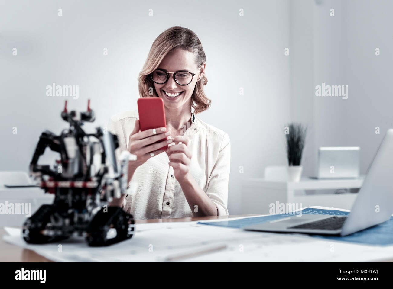Joyful female person taking photo of robot Stock Photo - Alamy