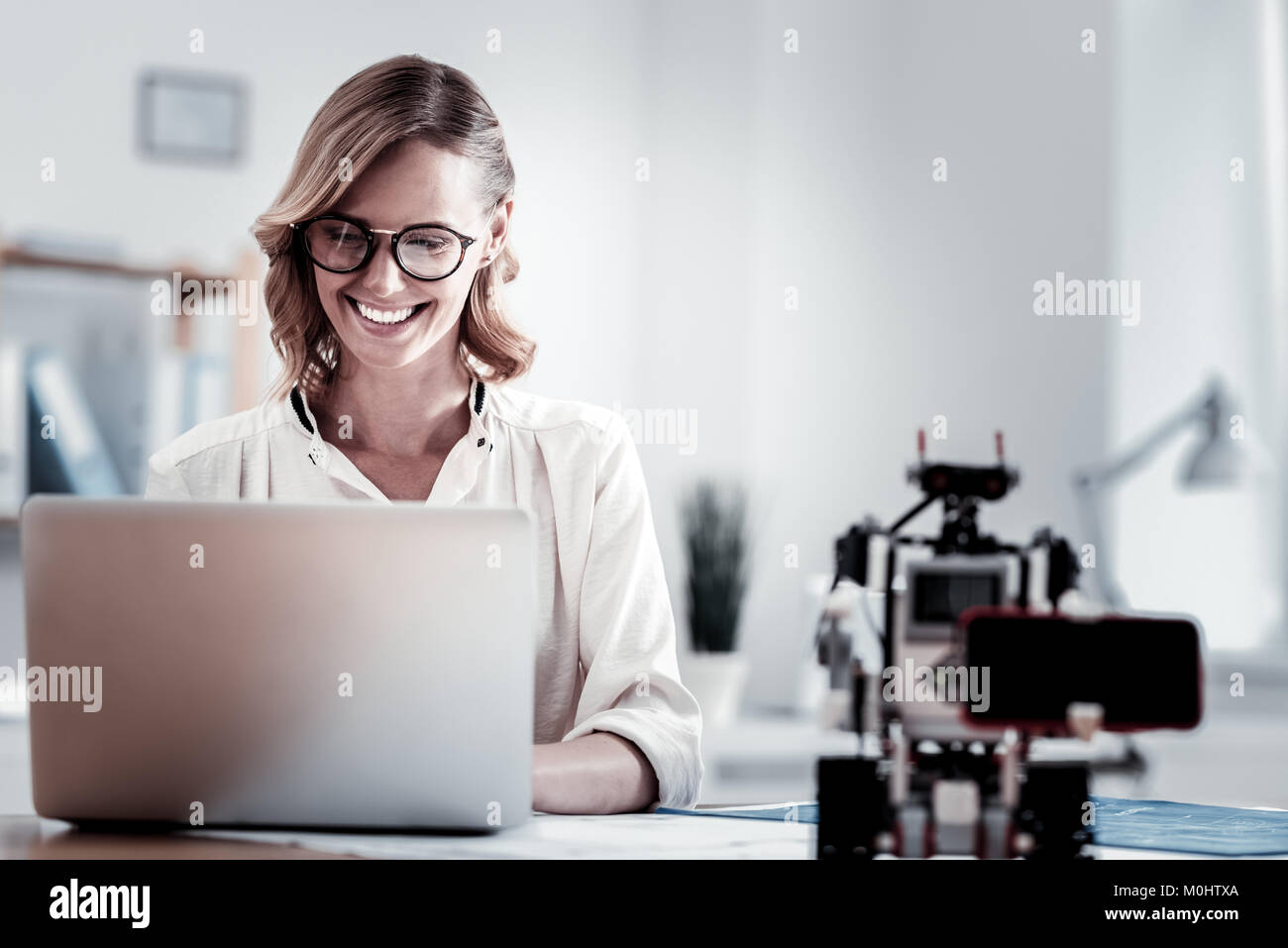 Cheerful female looking at screen of her computer Stock Photo - Alamy