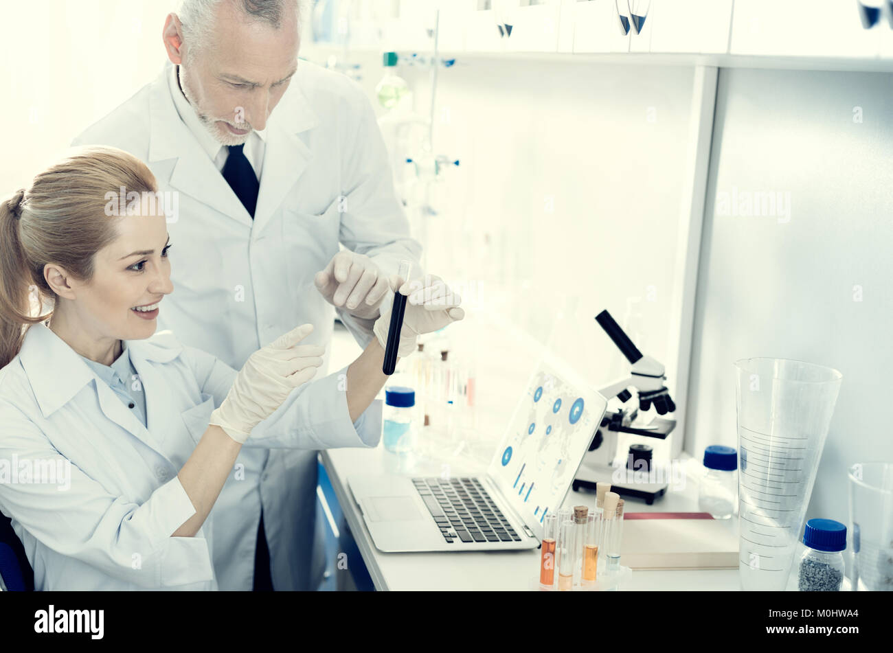 Laboratory workers discussing chemical liquid during experiment Stock ...