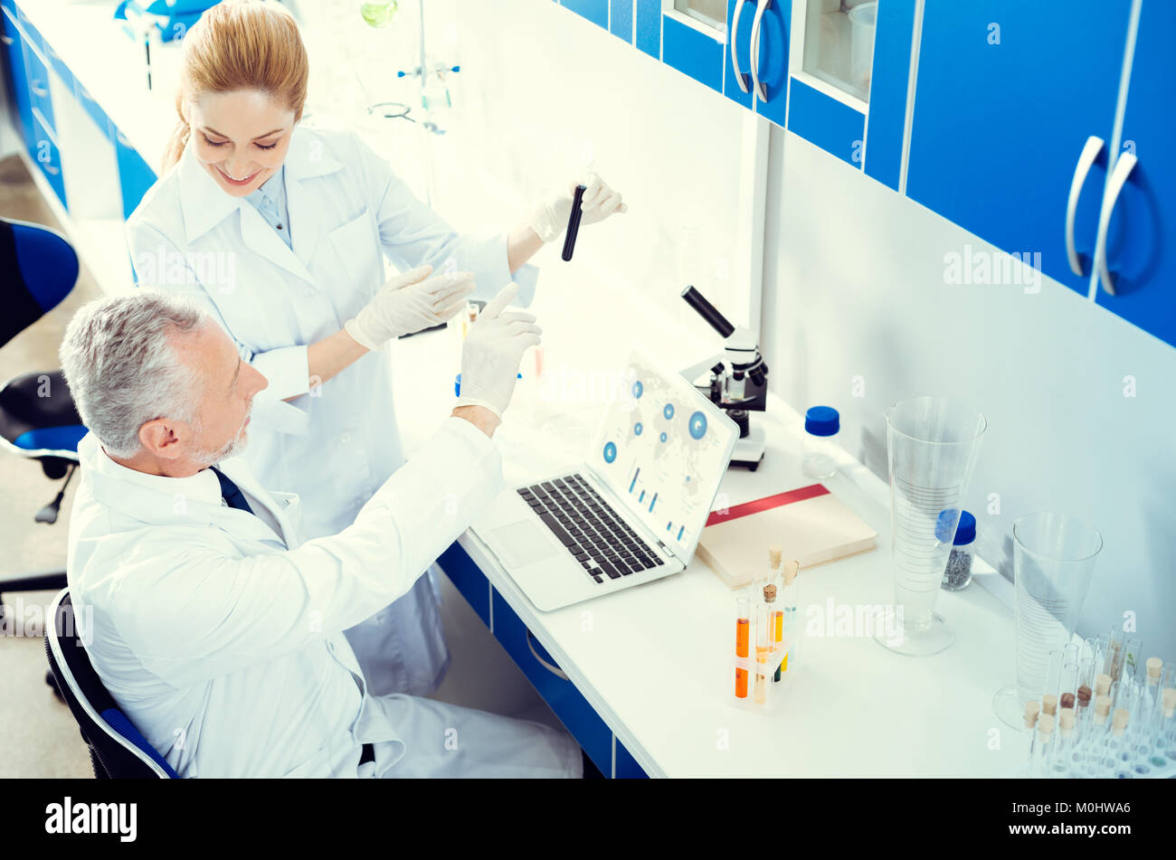 Smiling statists consulting during chemical experiment Stock Photo - Alamy
