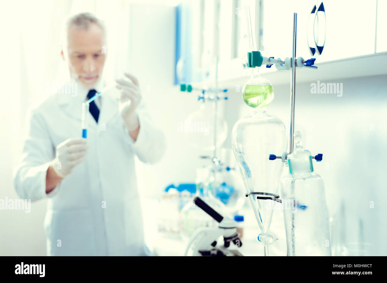 Male lab worker conducting chemical experiment Stock Photo - Alamy