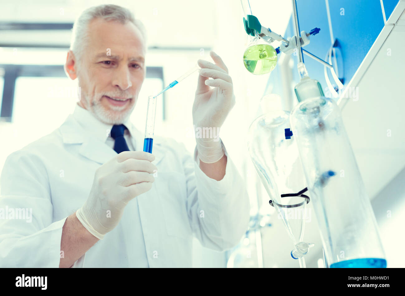 Positive minded scientist mixing chemical liquids in lab Stock Photo ...