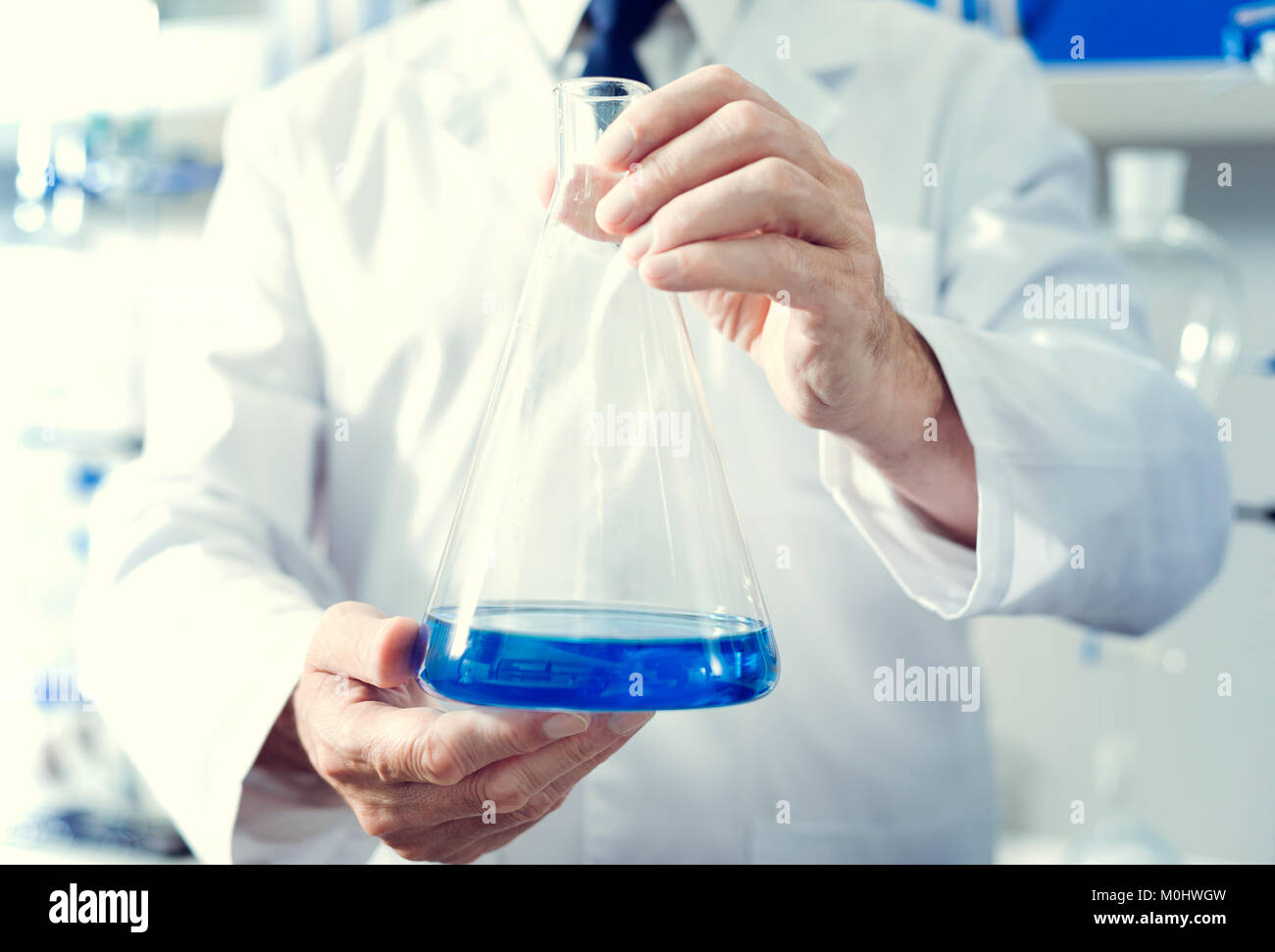 Close up of male scientist holding flask Stock Photo - Alamy