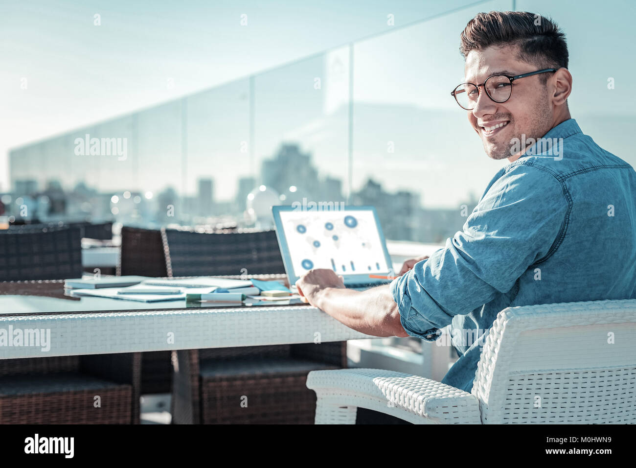 Smart self employed guy smiling while working outdoors Stock Photo - Alamy