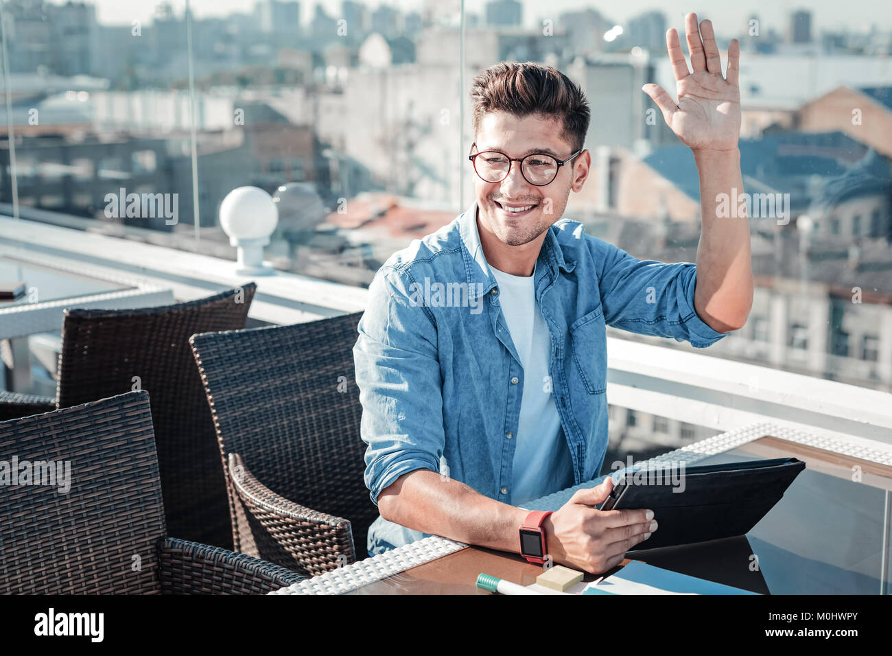 Friendly guy waving his hand while greeting somebody Stock Photo - Alamy