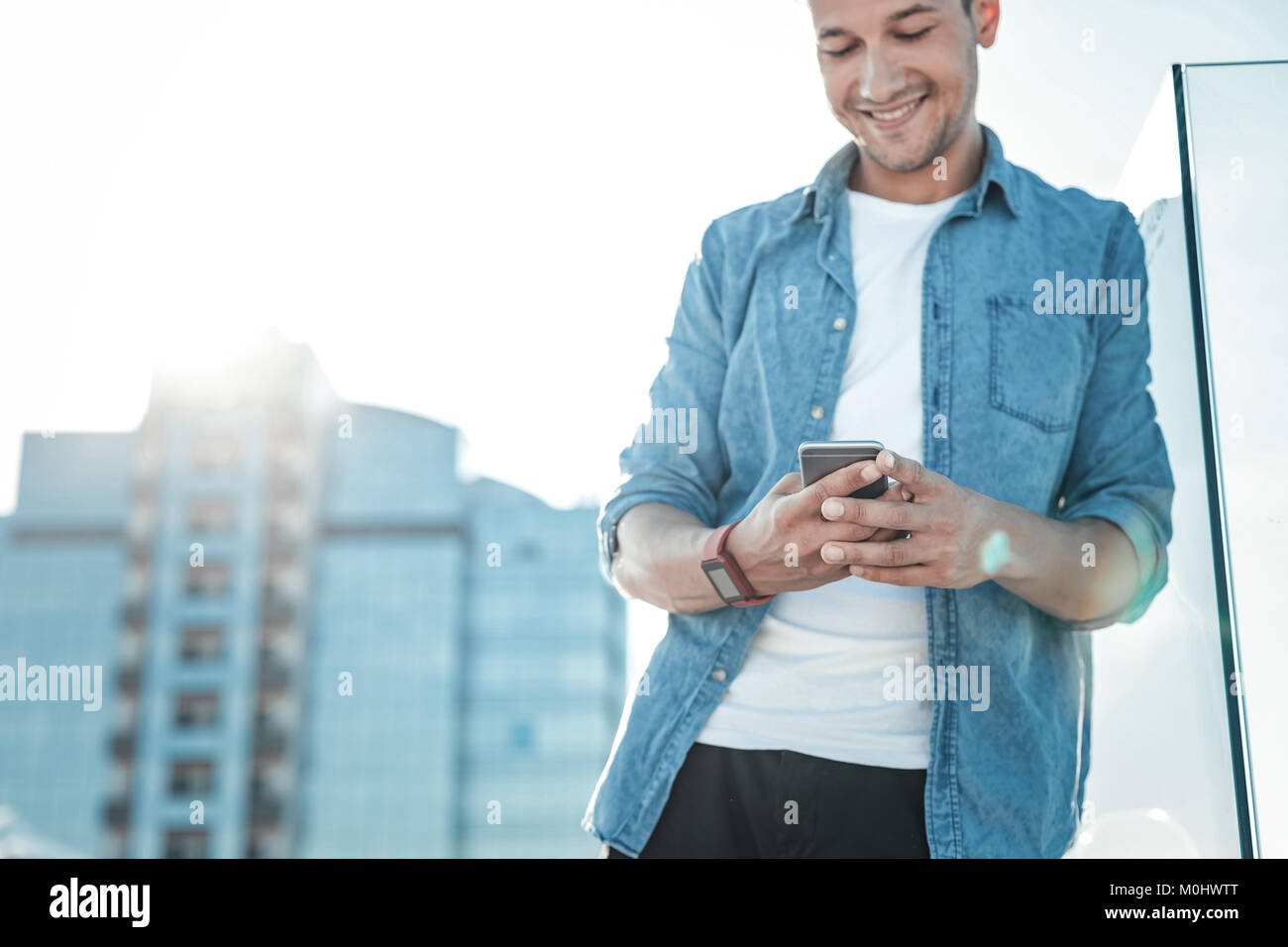 Smiling gentleman typing message while standing outdoors Stock Photo ...