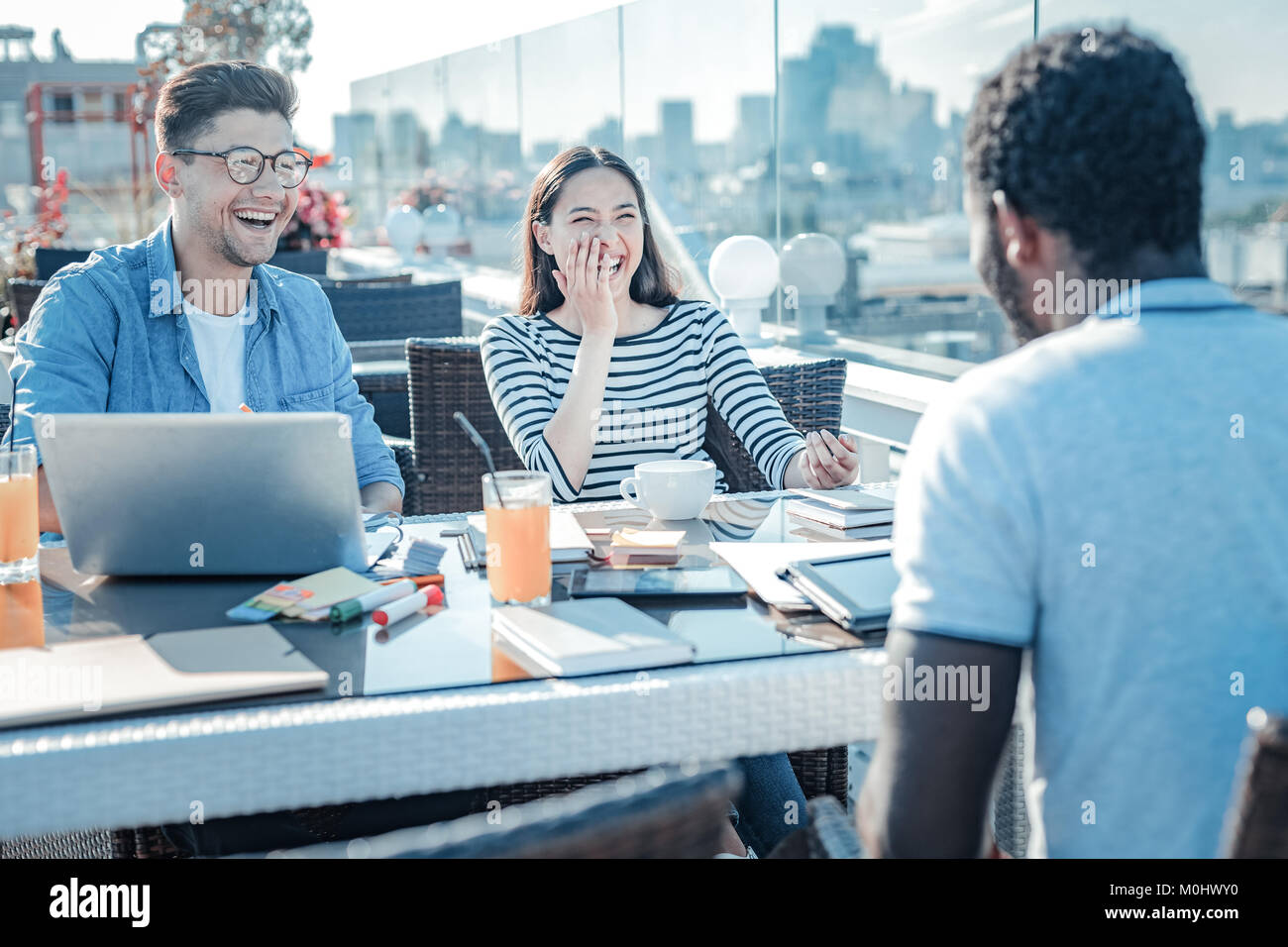 Funny college mates laughing while studying together Stock Photo - Alamy