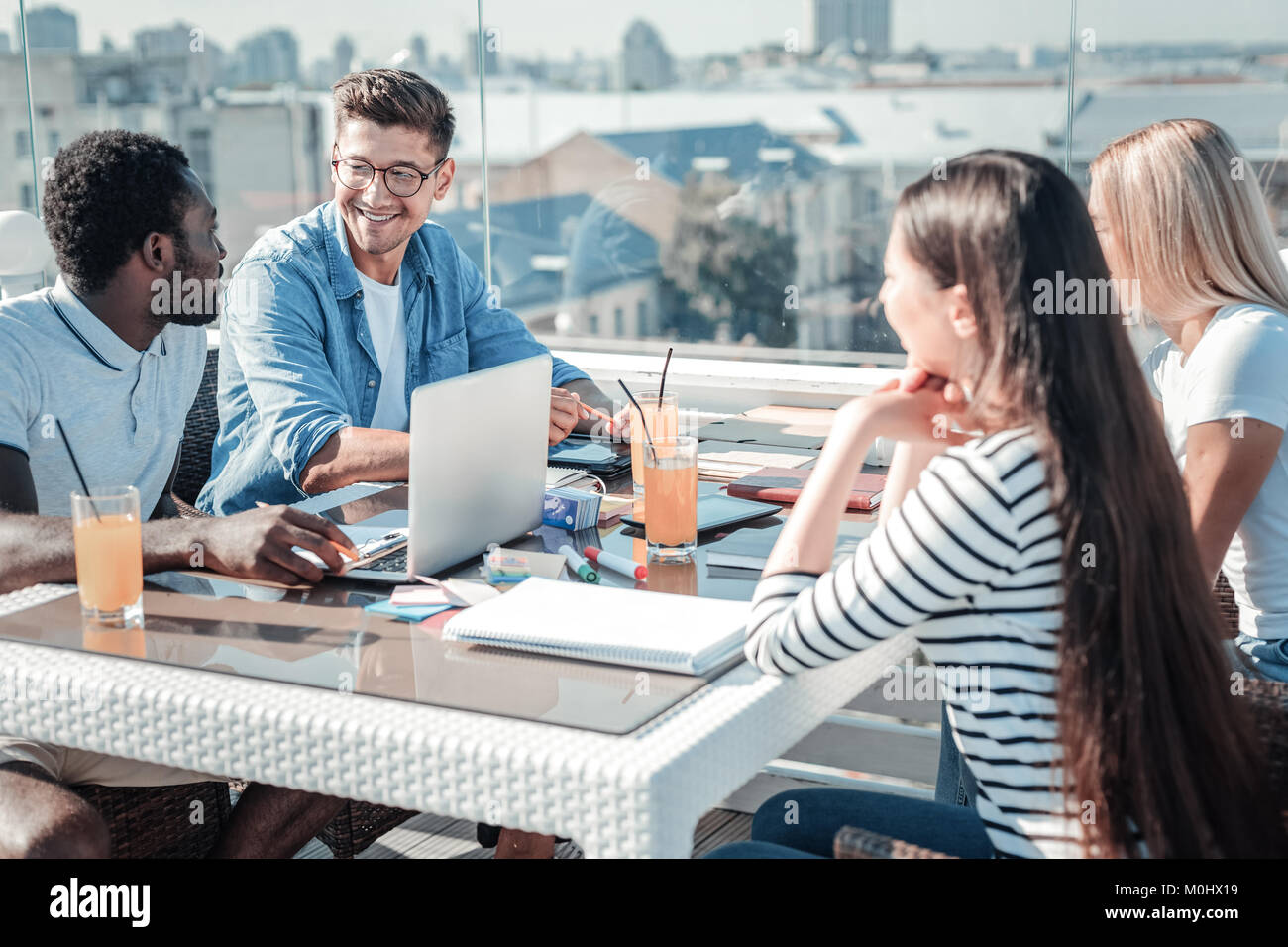 Relaxed young people smiling while discussing something Stock Photo - Alamy