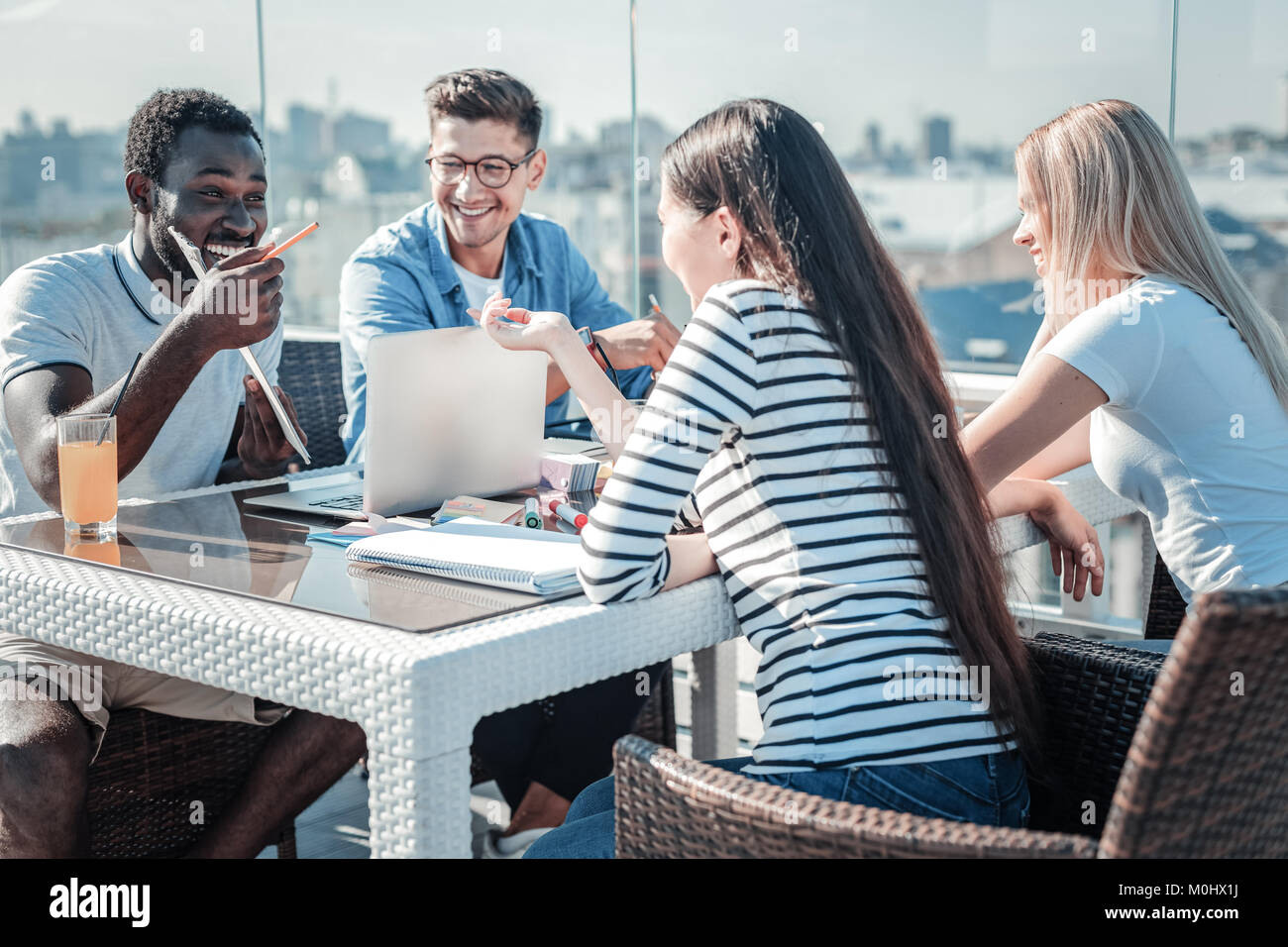 Radiant students discussing college project and smiling Stock Photo - Alamy