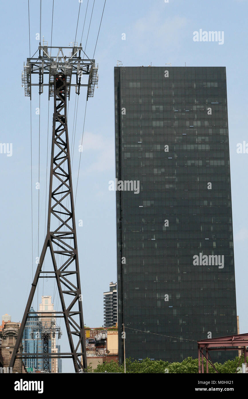 An apartment building next to an electricity pylon against blue sky ...