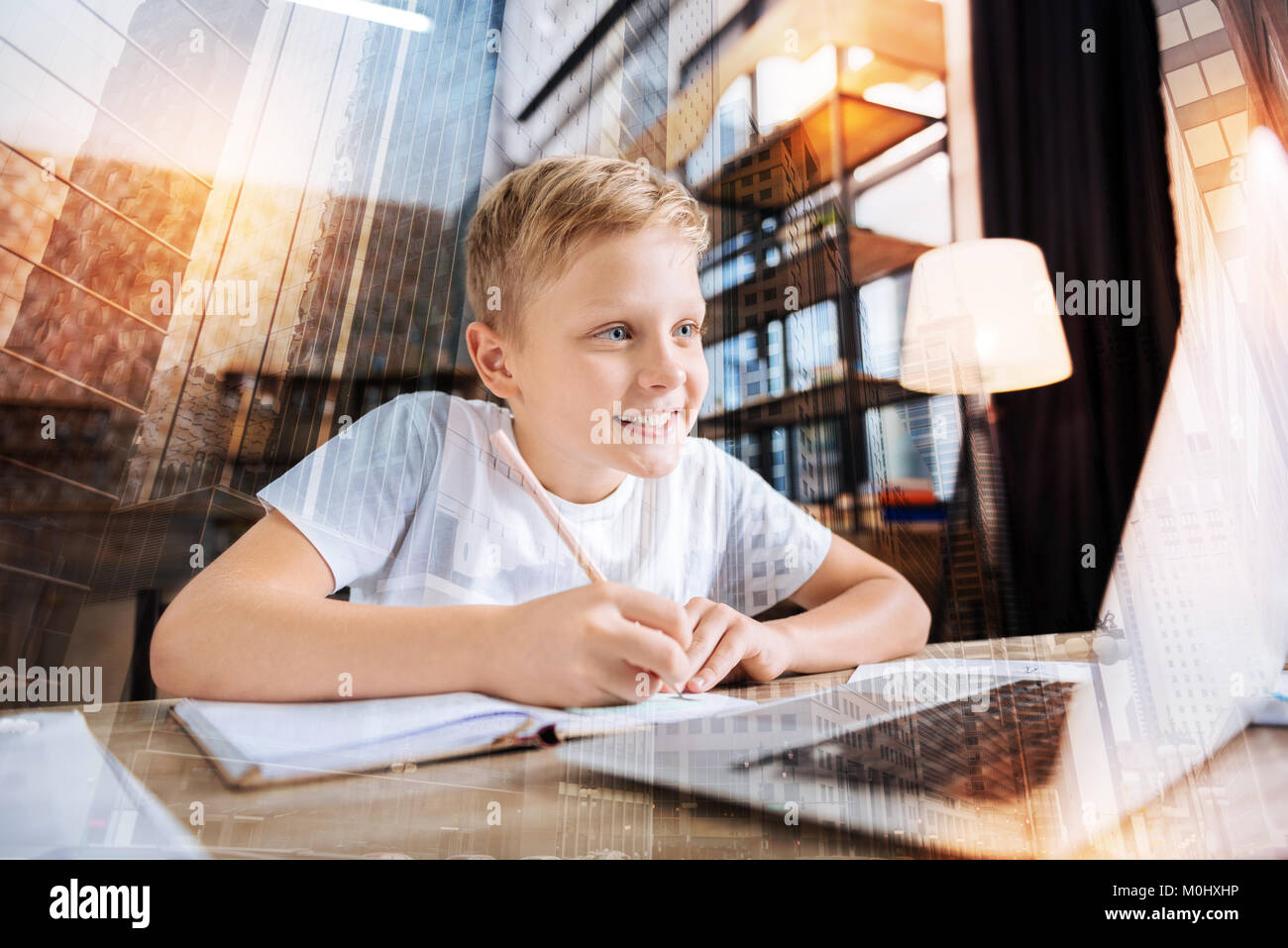 Smart boy smiling while doing his homework Stock Photo - Alamy