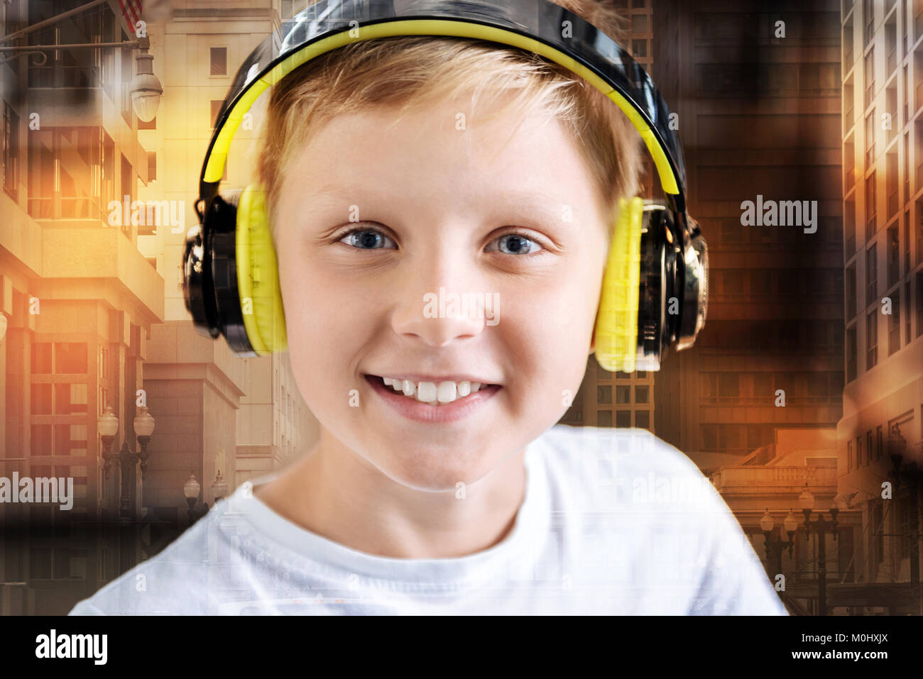 Cheerful lovely boy smiling and listening to music Stock Photo - Alamy