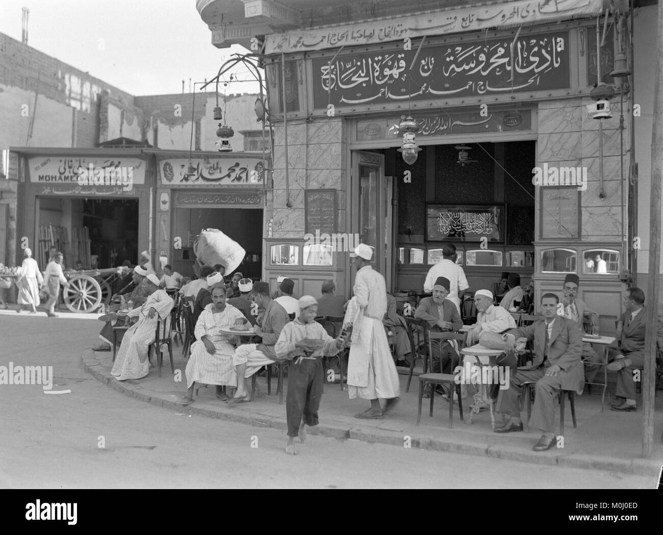 A photograph of a café terrace in Cairo, Egypt, depicting everyday ...