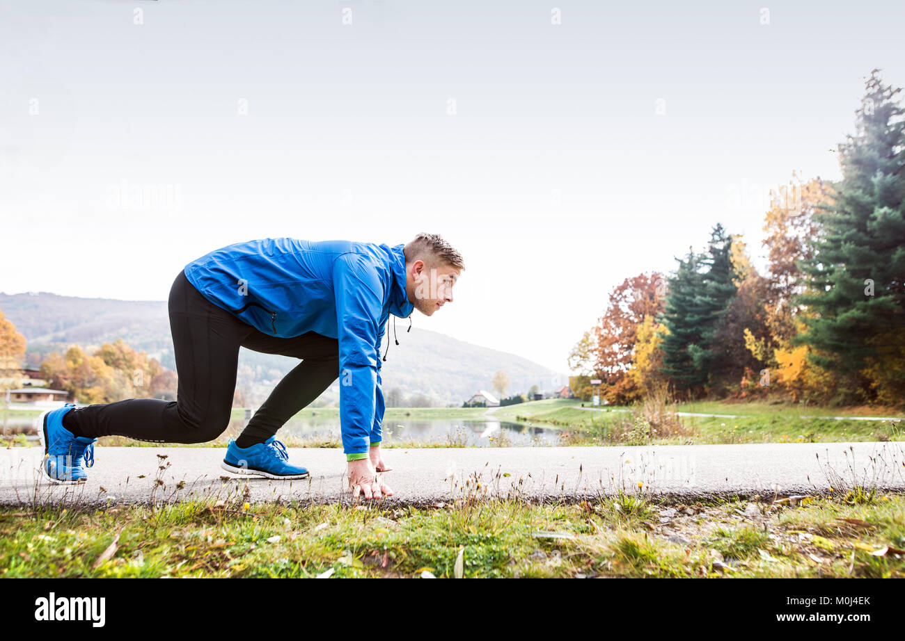 Runner at the lake on asphalt path in steady position Stock Photo - Alamy