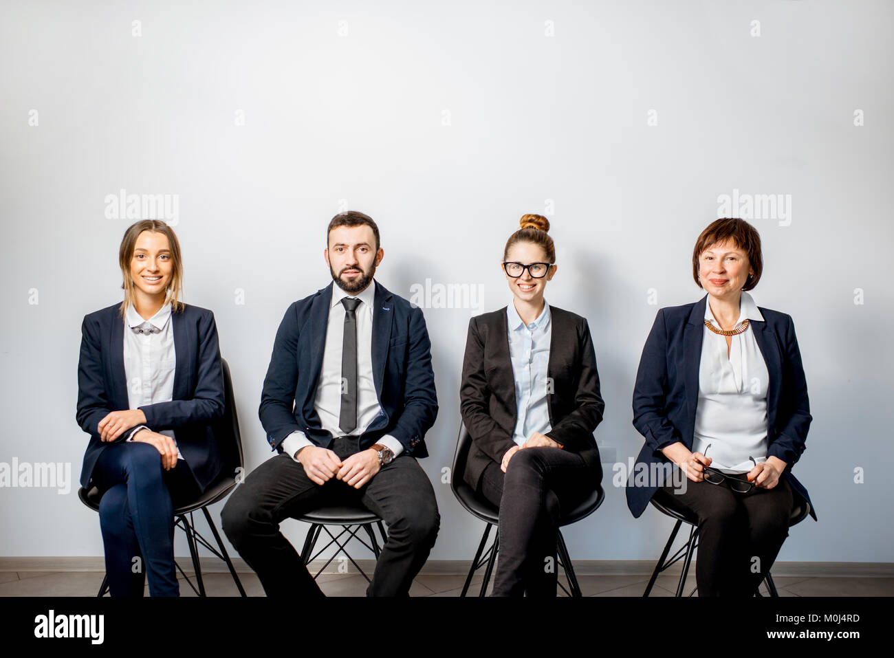 Business people sitting in a row Stock Photo - Alamy