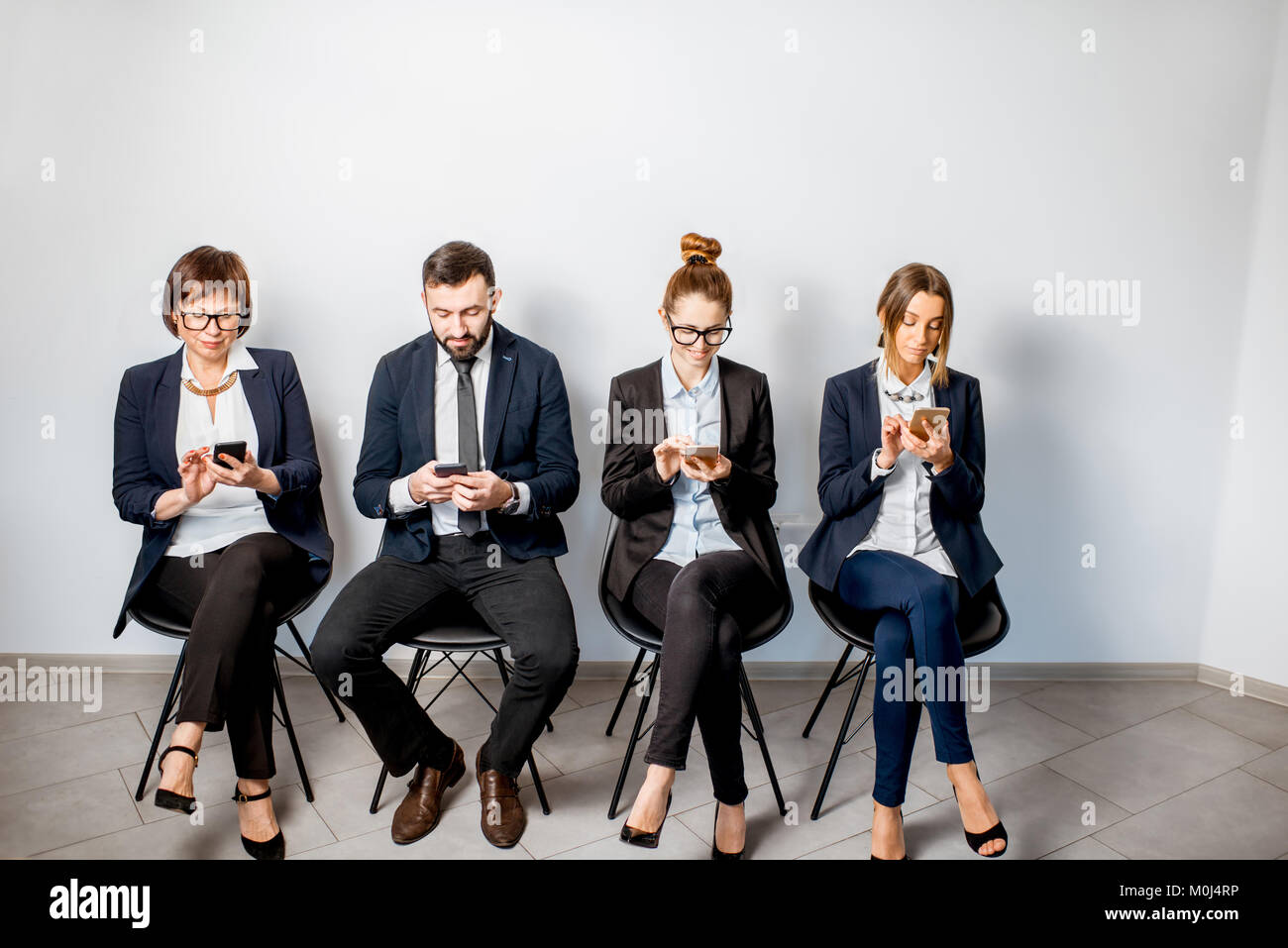 Business people sitting in a row Stock Photo - Alamy
