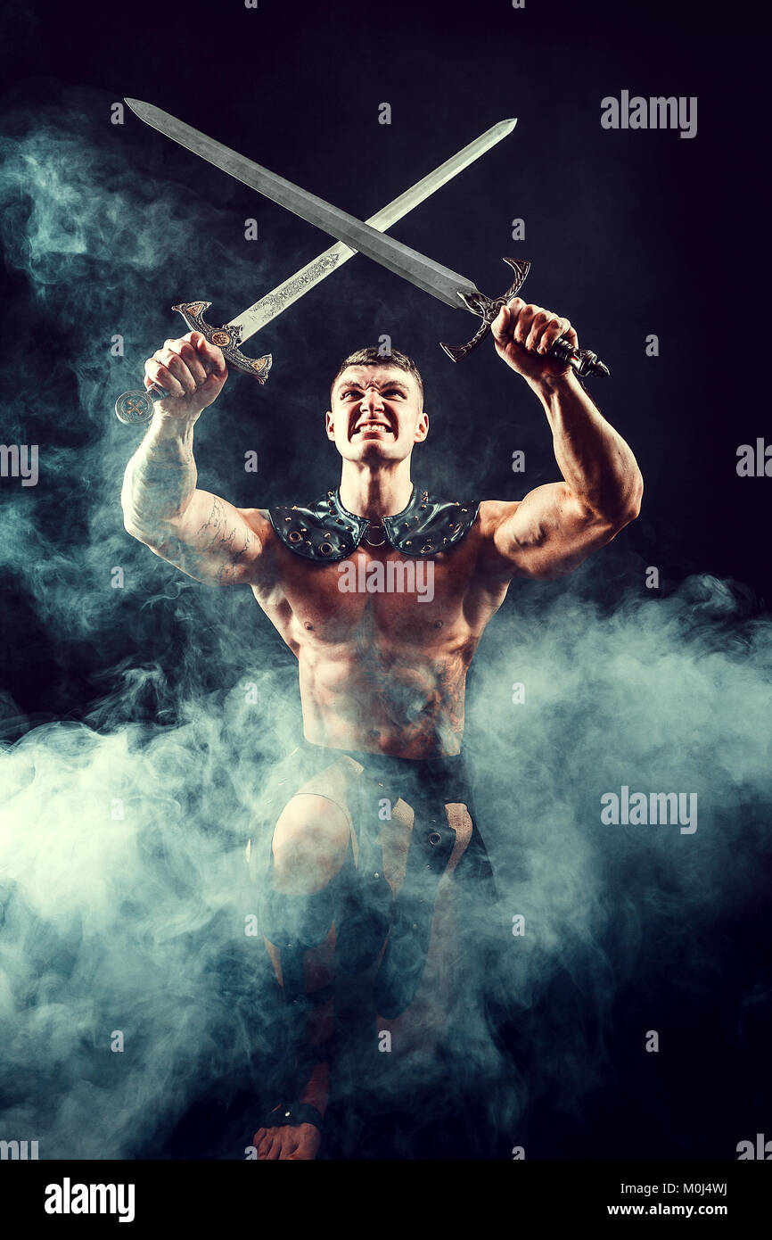 Aggressive expressive warrior crossing swords above head posing in ...