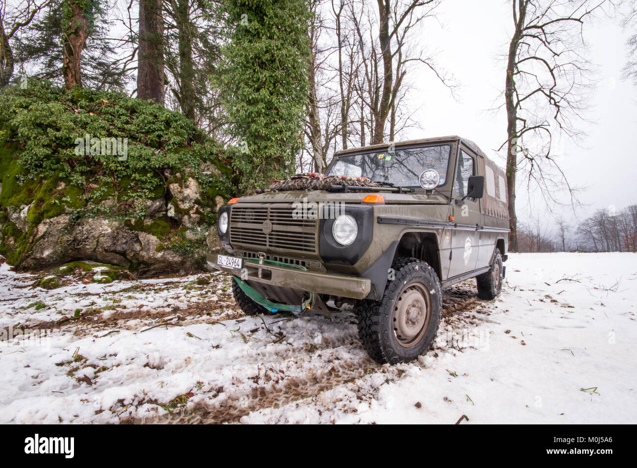 4x4 Puch army vehicle parking in front of a forest and rocks on a cold ...