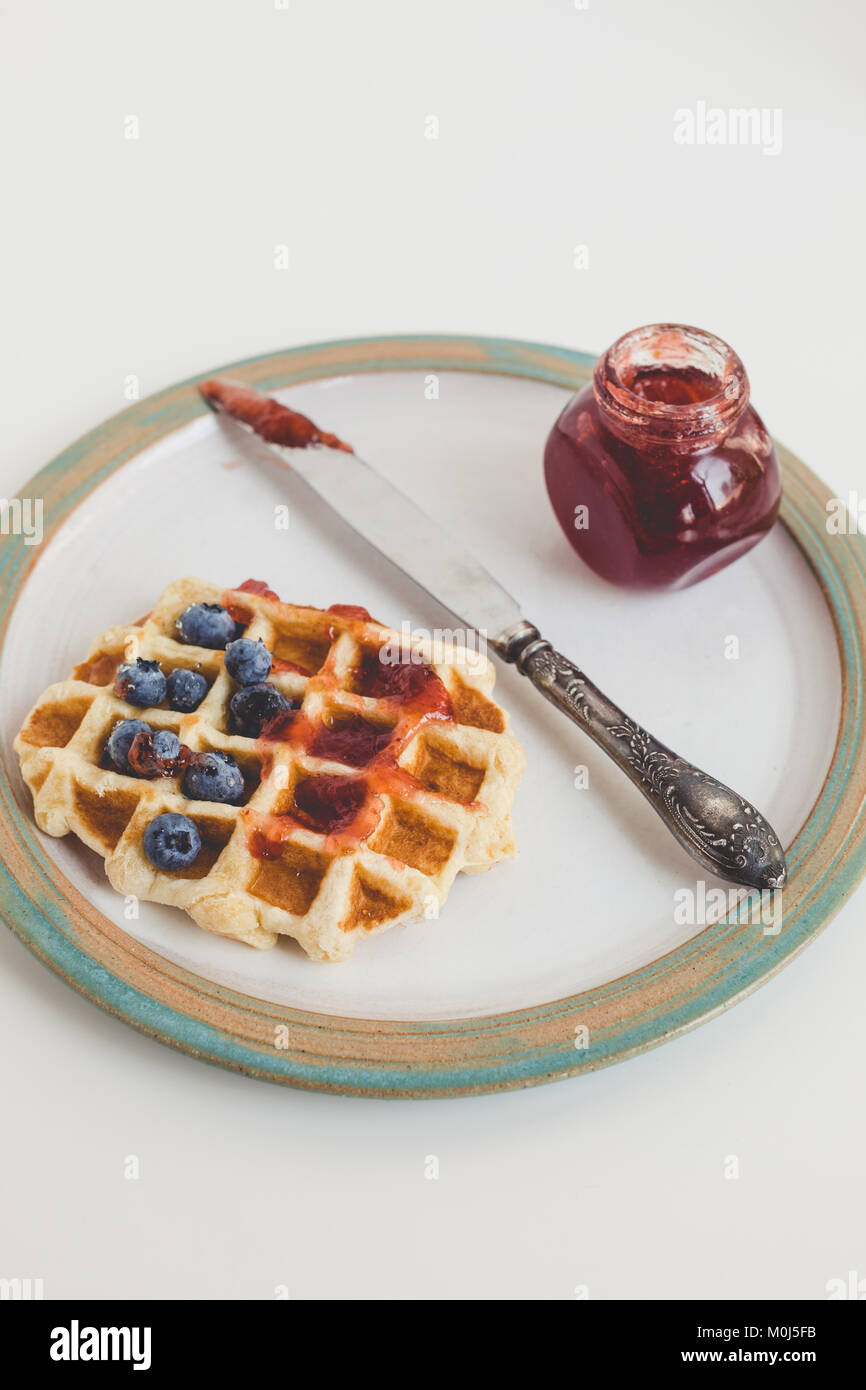 tasty waffle with jam, blueberries and knife on vintage plate Stock ...
