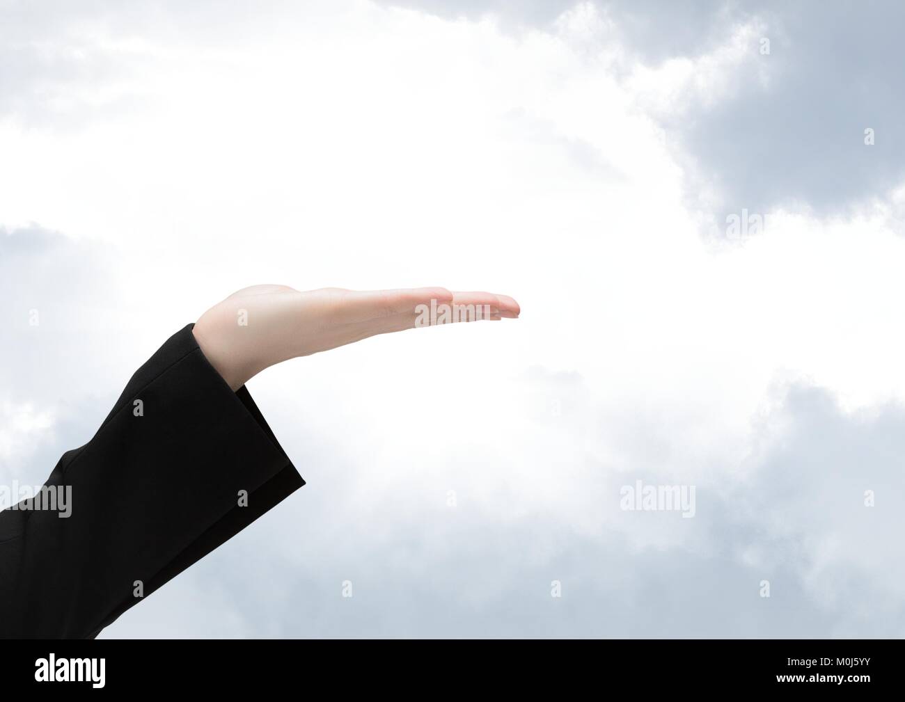 Hand open with sky clearing bright Stock Photo - Alamy