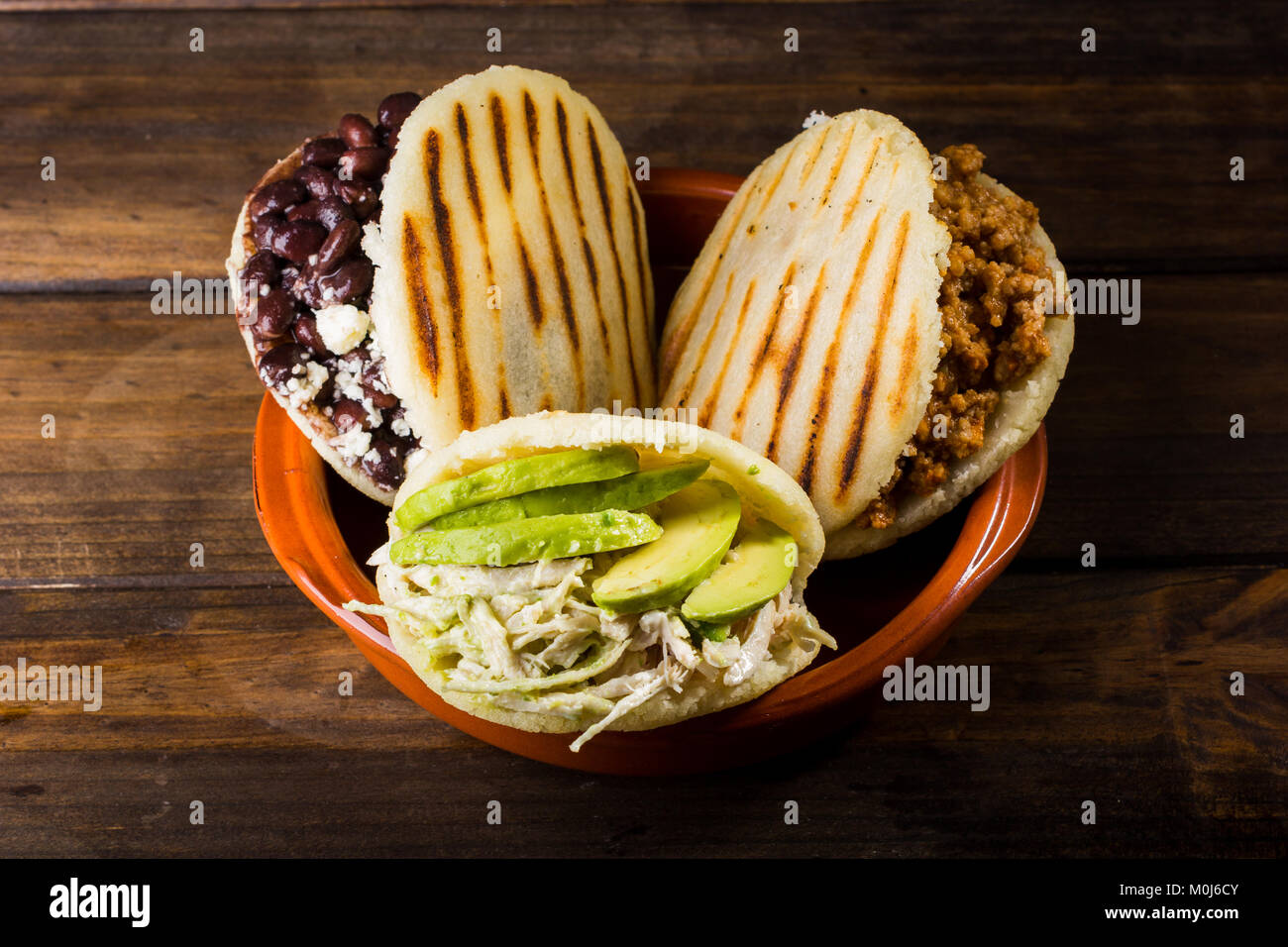 Three types of arepas, Latin American food on wood table Stock Photo ...
