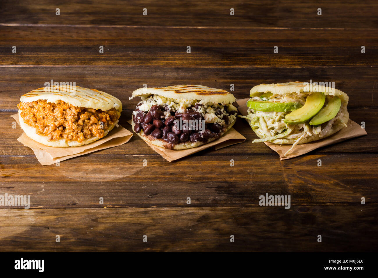 Three types of arepas, Latin American food on wood table Stock Photo ...