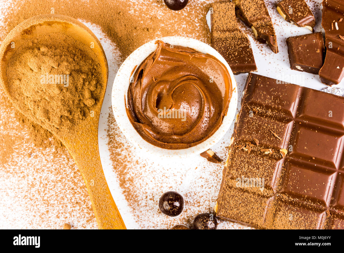 frame with different types of chocolate, powder, cream and bar on a ...