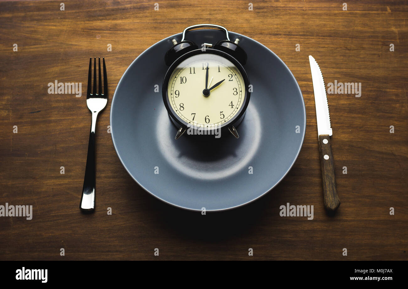 Alarm clock inside a plate Stock Photo - Alamy