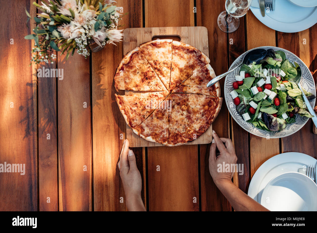 Top view of female hands setting food on the table for a party. Woman ...