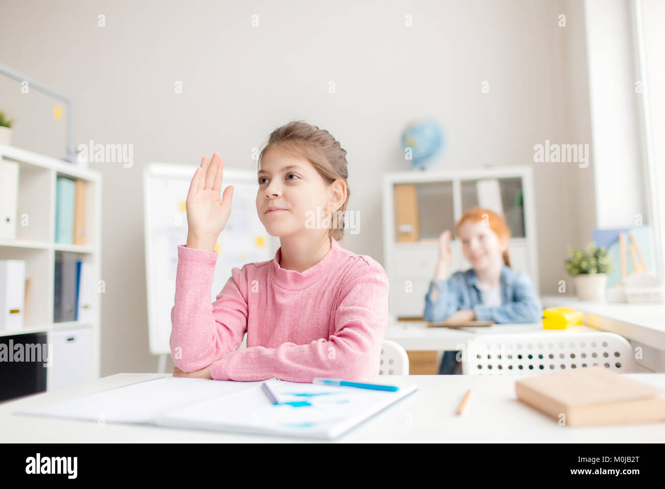 Girl raising hand Stock Photo - Alamy