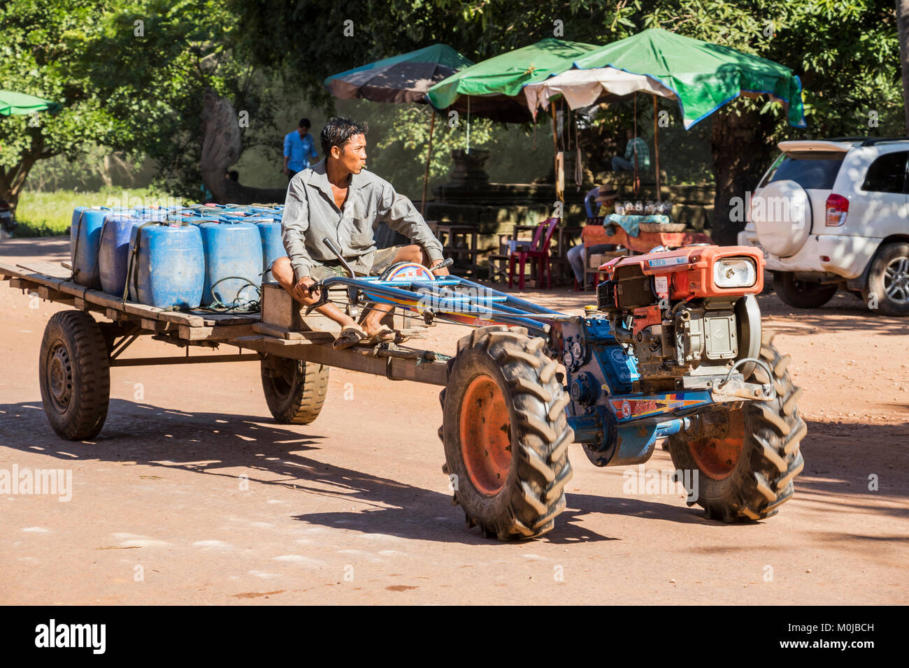 Man riding a tractor down the street, Beng Meala; Siem Reap, Cambodia ...